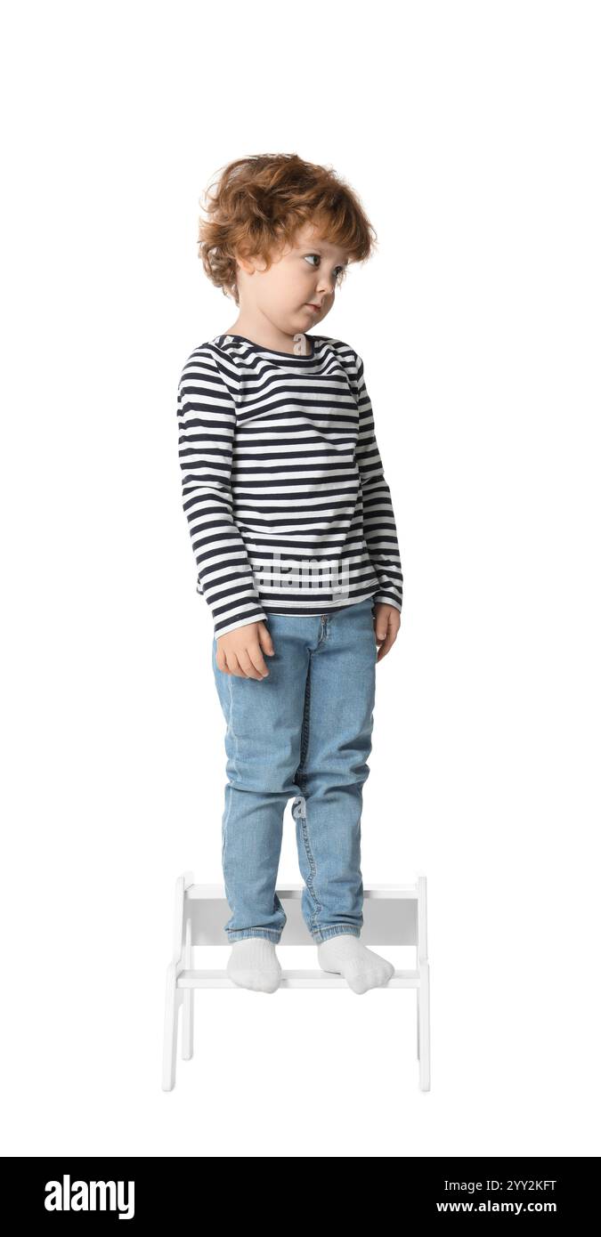 Little boy standing on step stool against white background Stock Photo ...