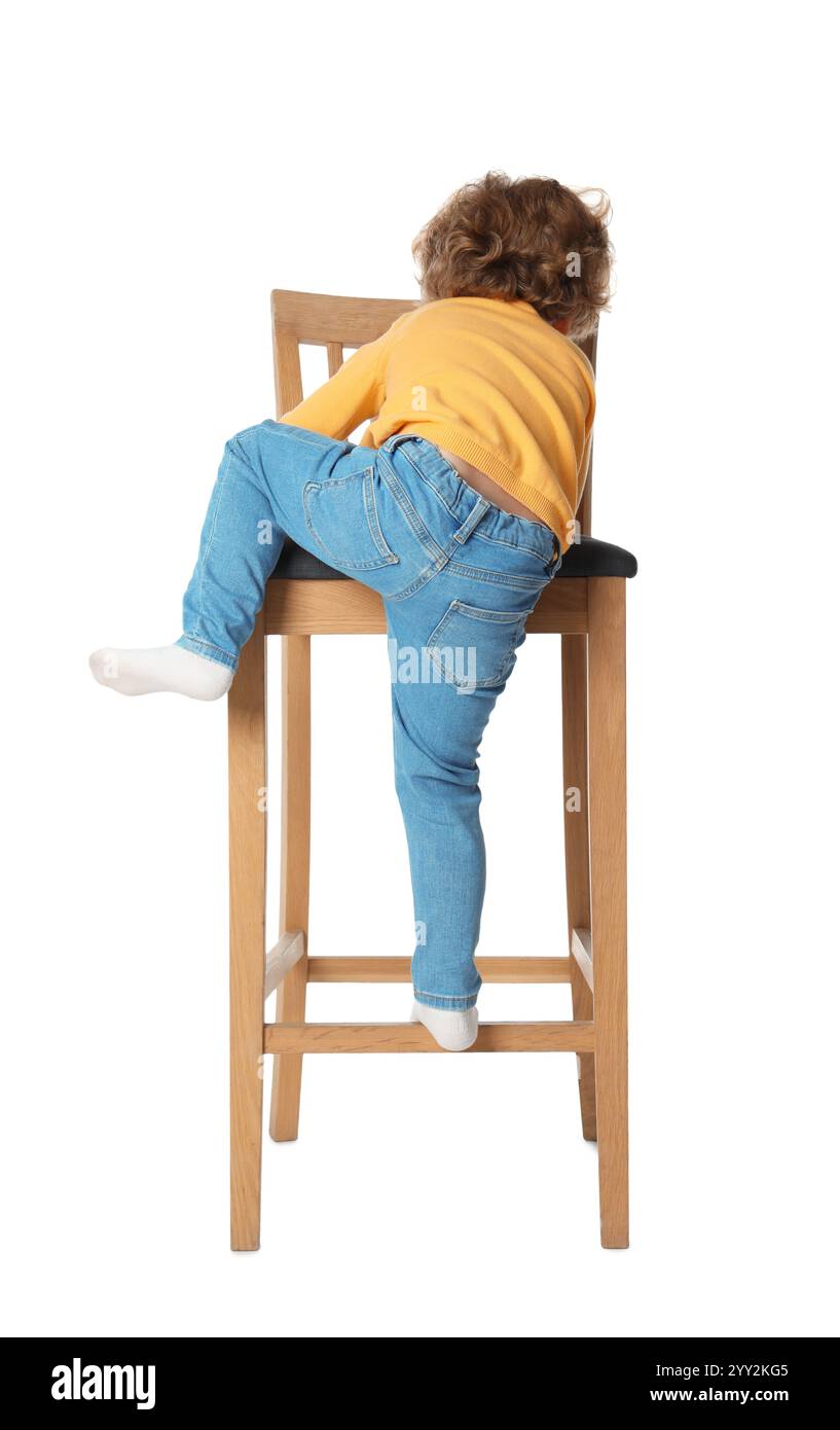 Little boy standing on stool against white background, back view Stock ...