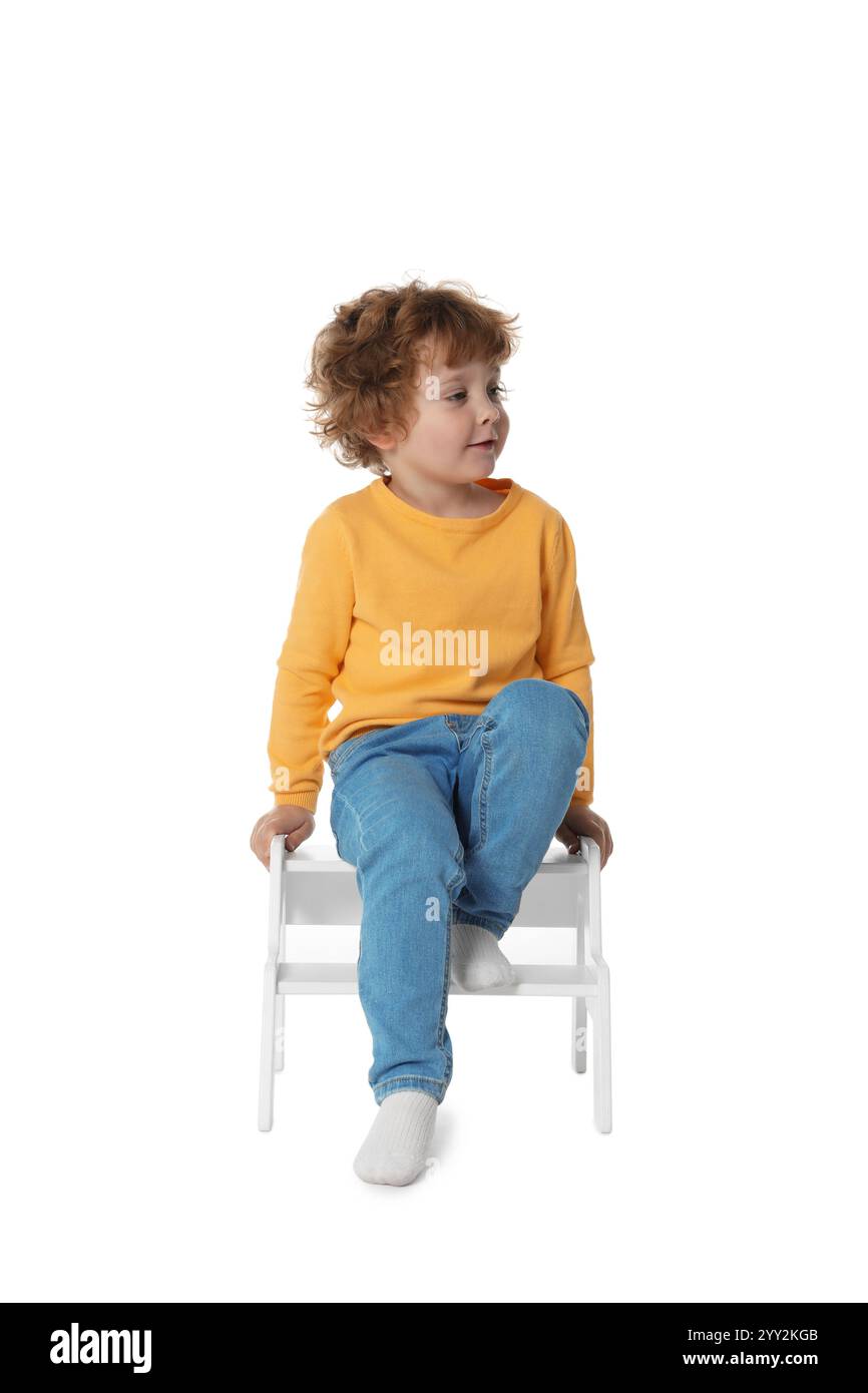 Little boy sitting on step stool against white background Stock Photo ...