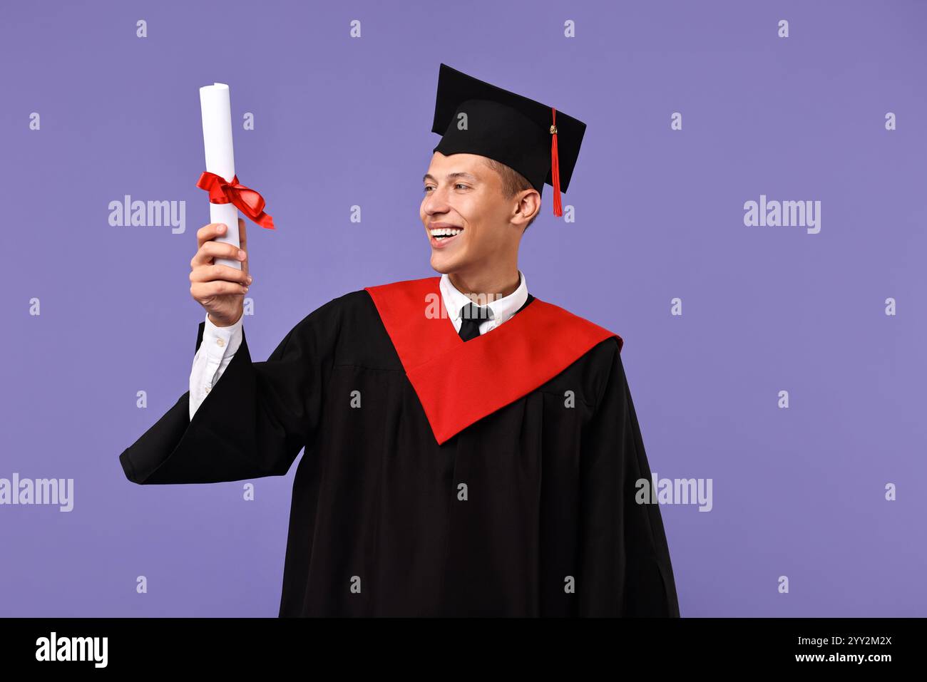 Happy student with diploma after graduation on violet background Stock ...
