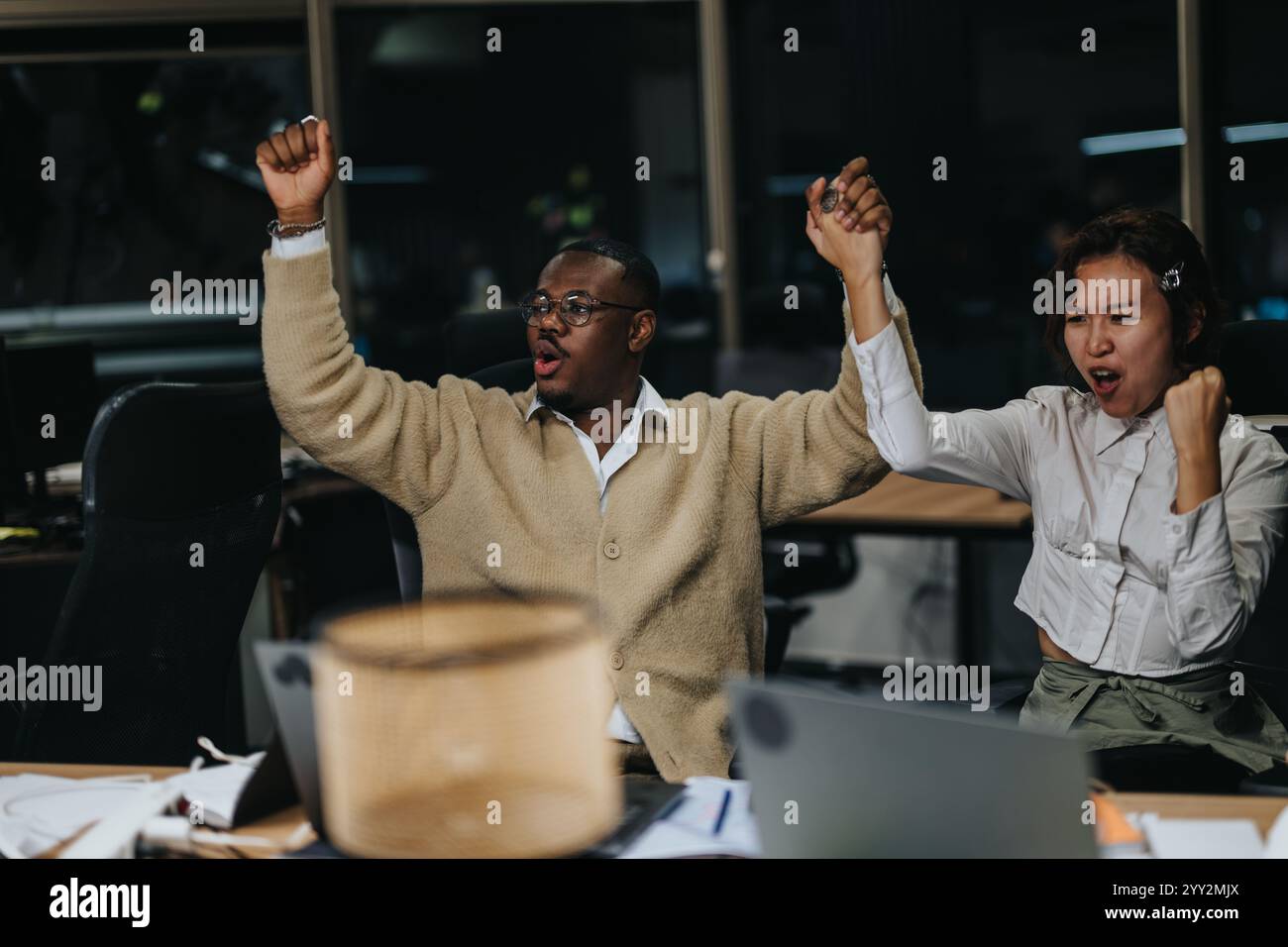 Diverse colleagues celebrating successful project completion at a late ...
