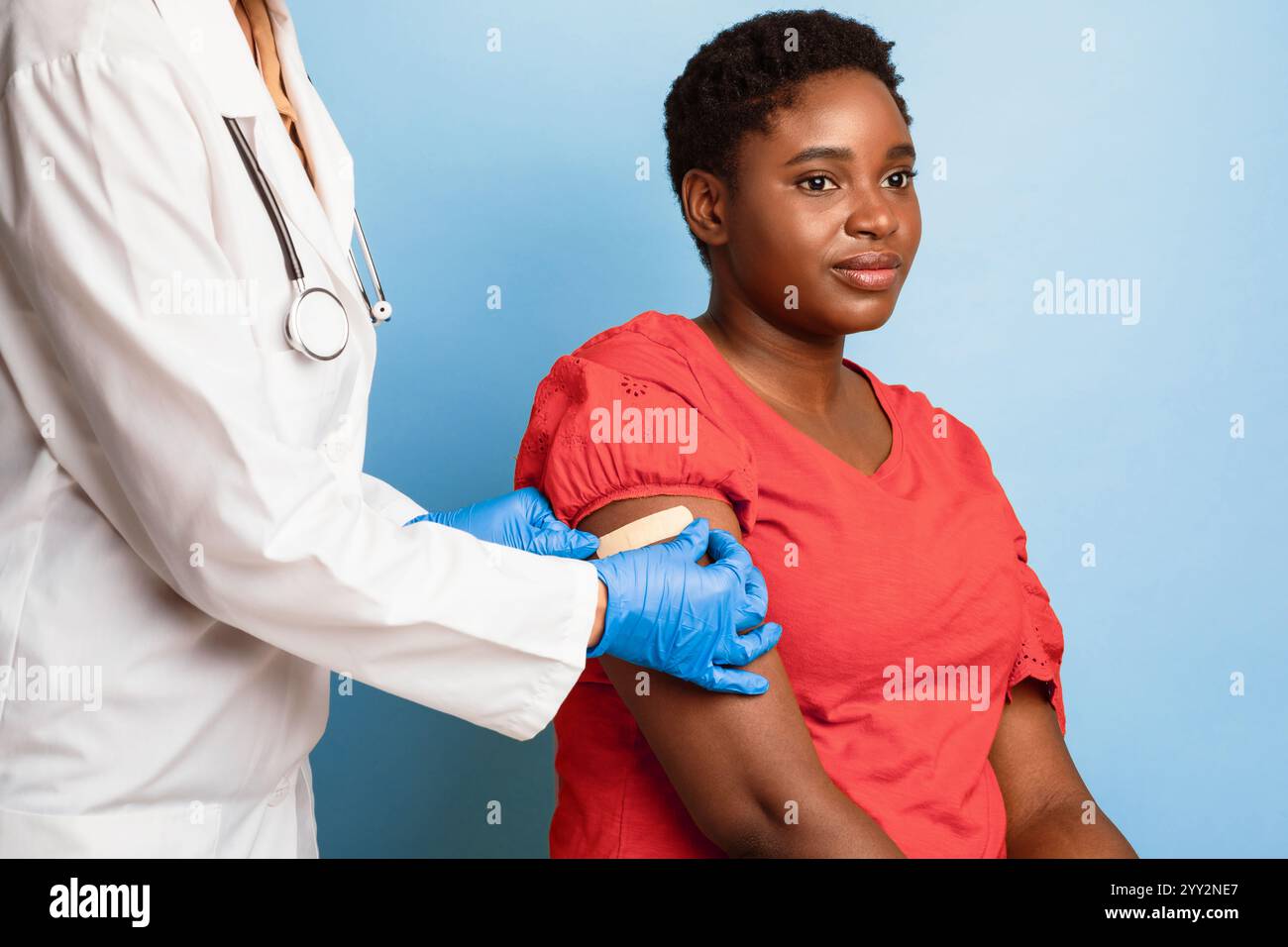 Nurse Applying Bandage After Vaccine Injection To Patient, Blue ...