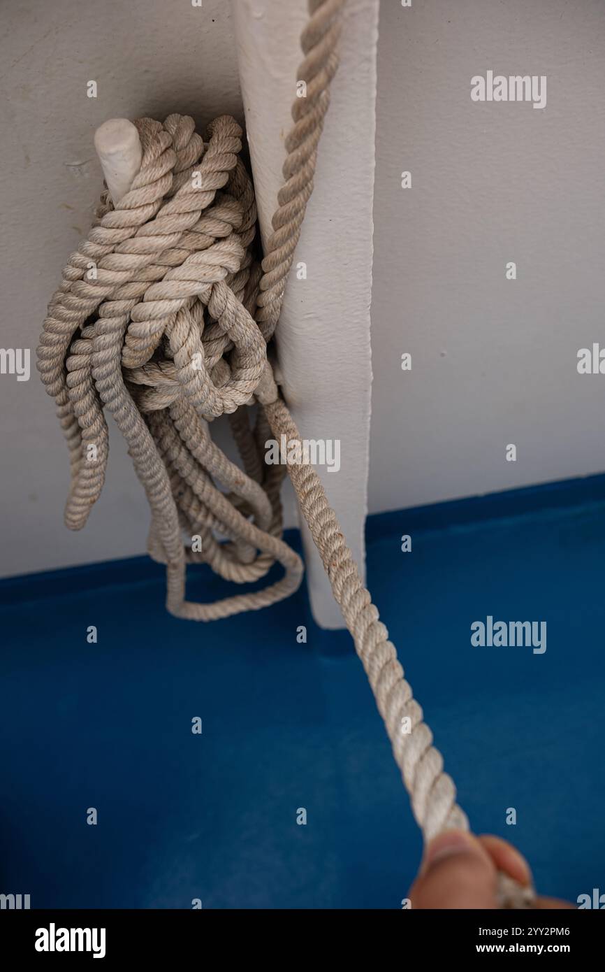 A rope is tied in a knot on the deck of a sea vessel. Close-up of a sea ...