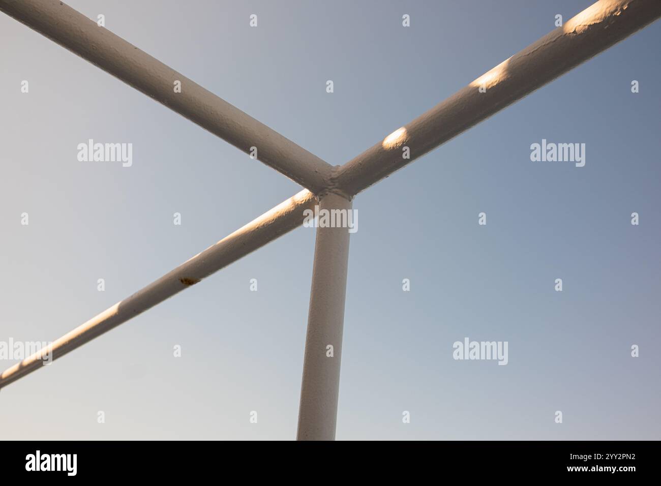 Pipe structure, abstract form of white metal pipes against blue sky ...