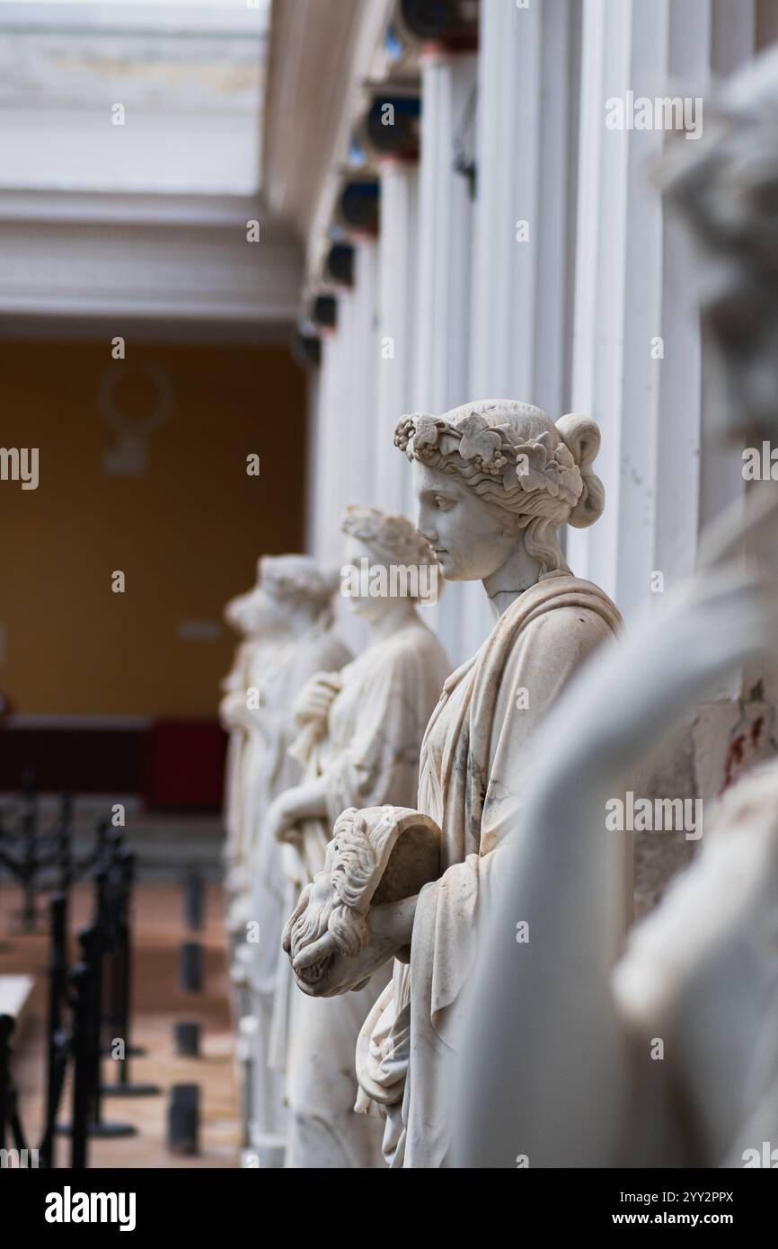 Antique statues of Women in Wreaths. The white stone statues stand in a ...