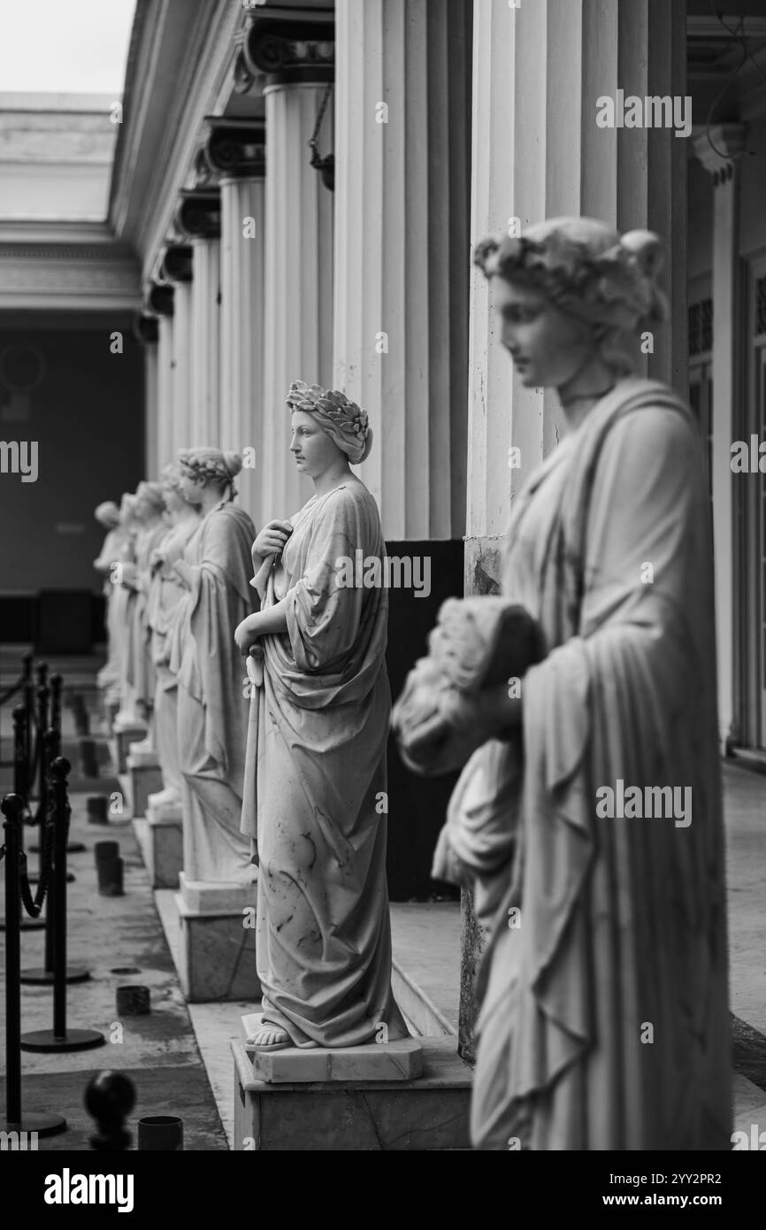 Antique statues of Women in Wreaths. The white stone statues stand in a ...