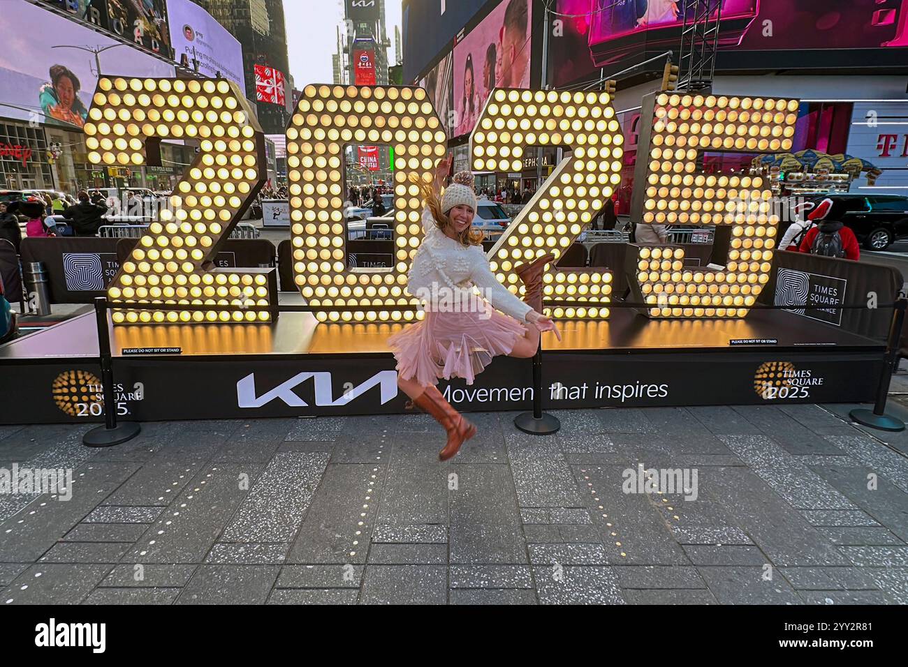 A dancer poses for photos in front of the 2025 New Year's Eve numerals ...