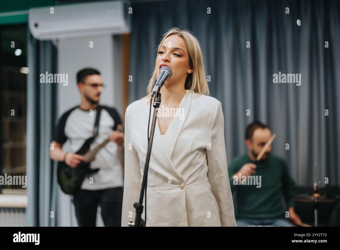 Female singer performing live with band during a captivating music ...