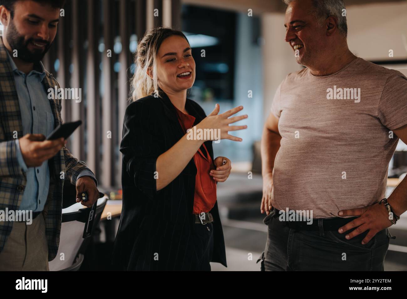 Colleagues sharing a conversation and laughter in the modern office ...