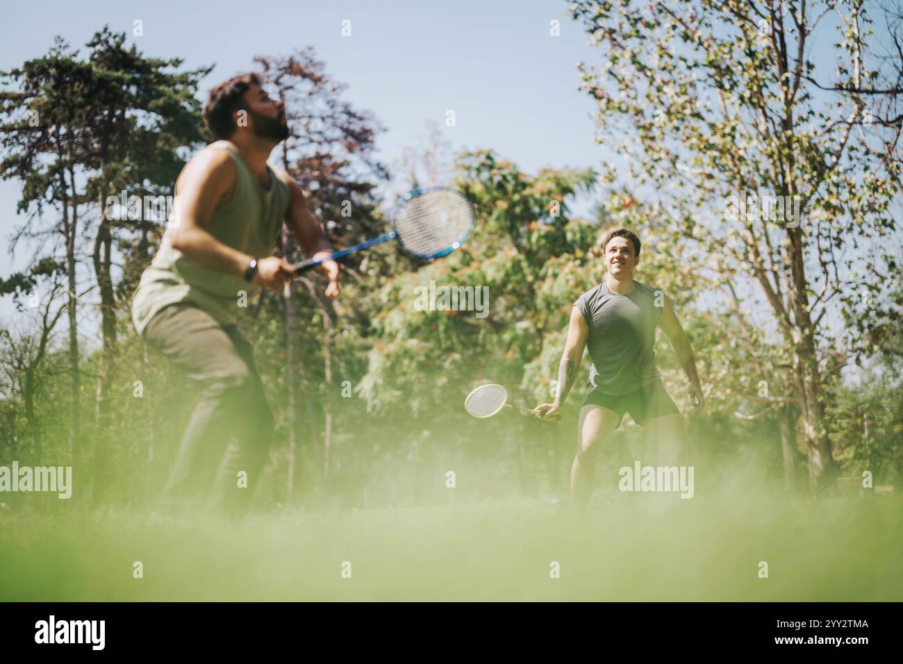 Two friends playing badminton in a sunny park setting Stock Photo - Alamy