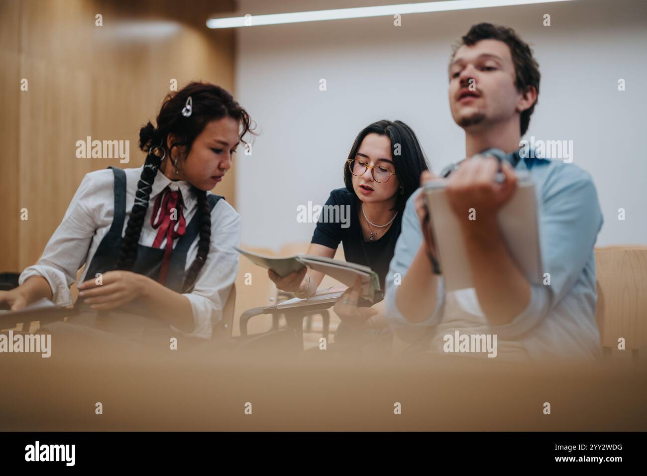 Students engaging in discussion with professor in a classroom setting ...