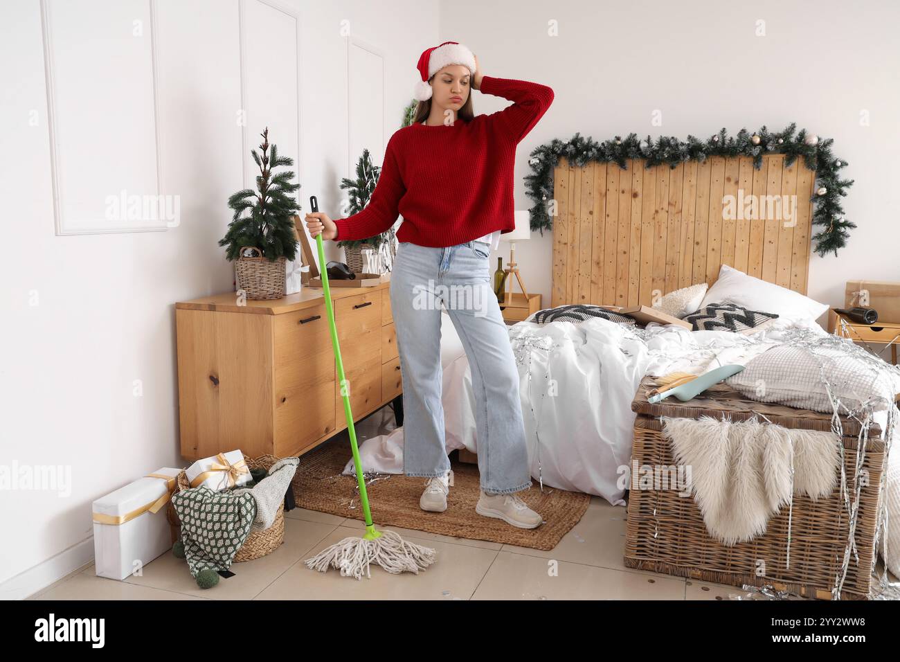 Young woman with mop in bedroom after New Year party Stock Photo - Alamy
