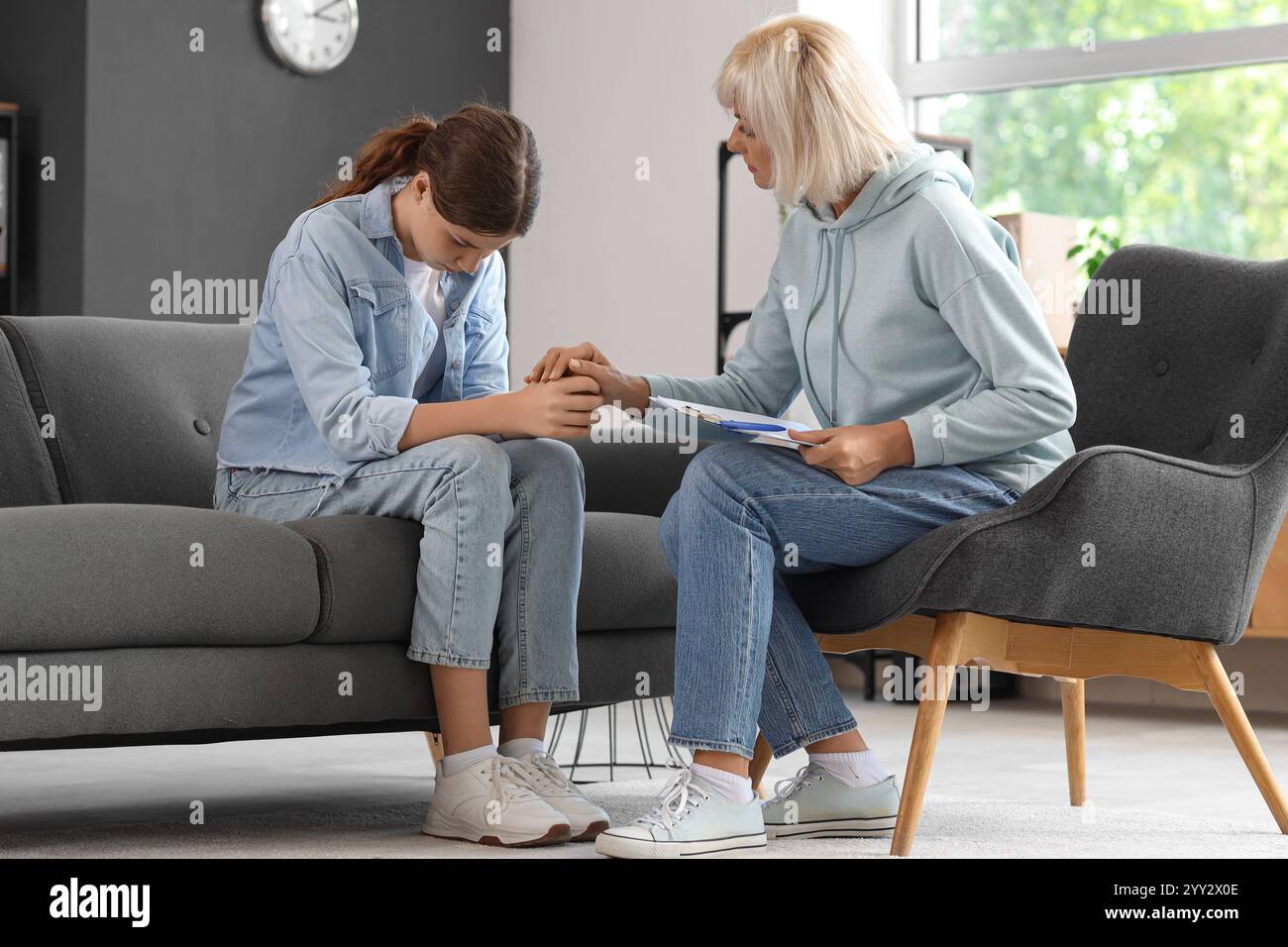Female psychologist calming sad teenage girl in office Stock Photo - Alamy
