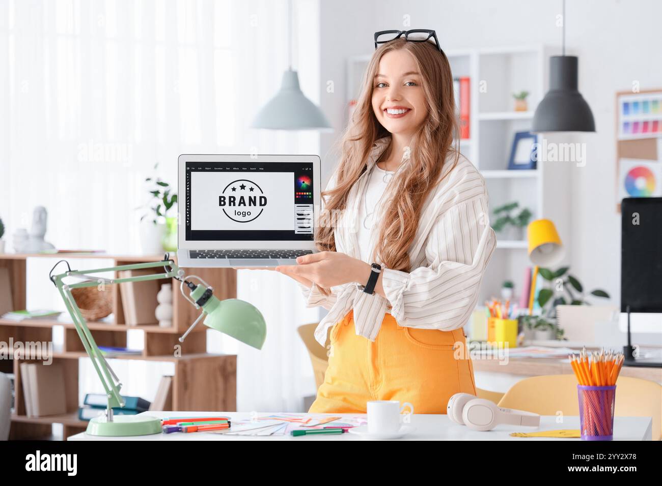 Female web designer with laptop in office Stock Photo - Alamy