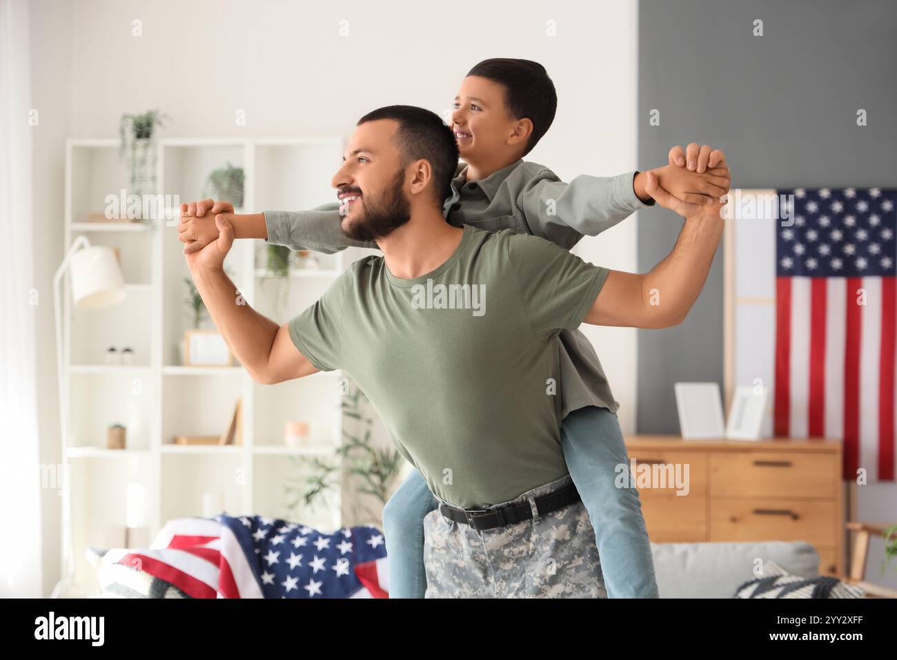 Happy little boy with his military father at home. Veterans Day ...