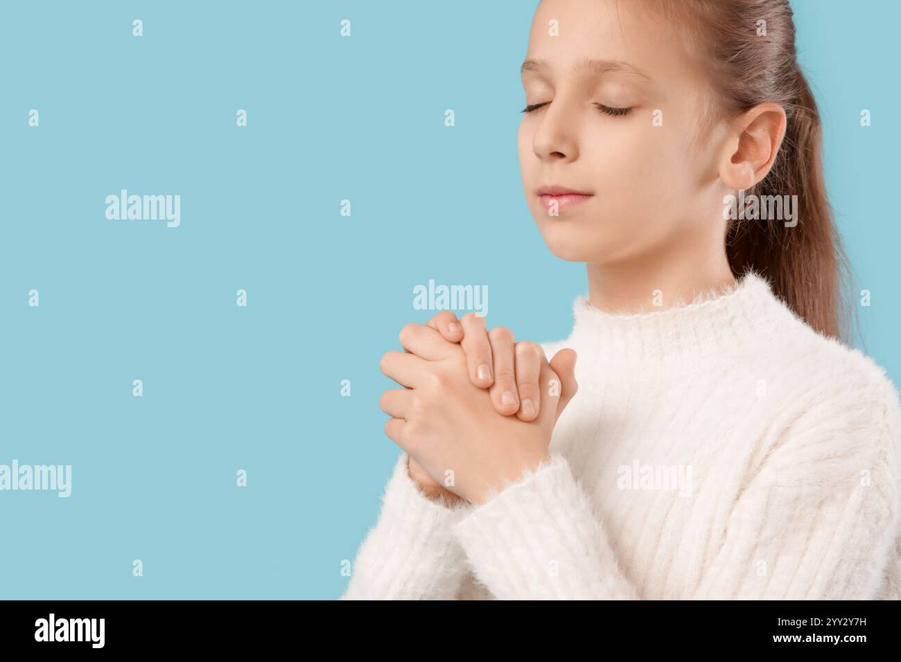 Teenage girl praying on blue background, closeup Stock Photo - Alamy