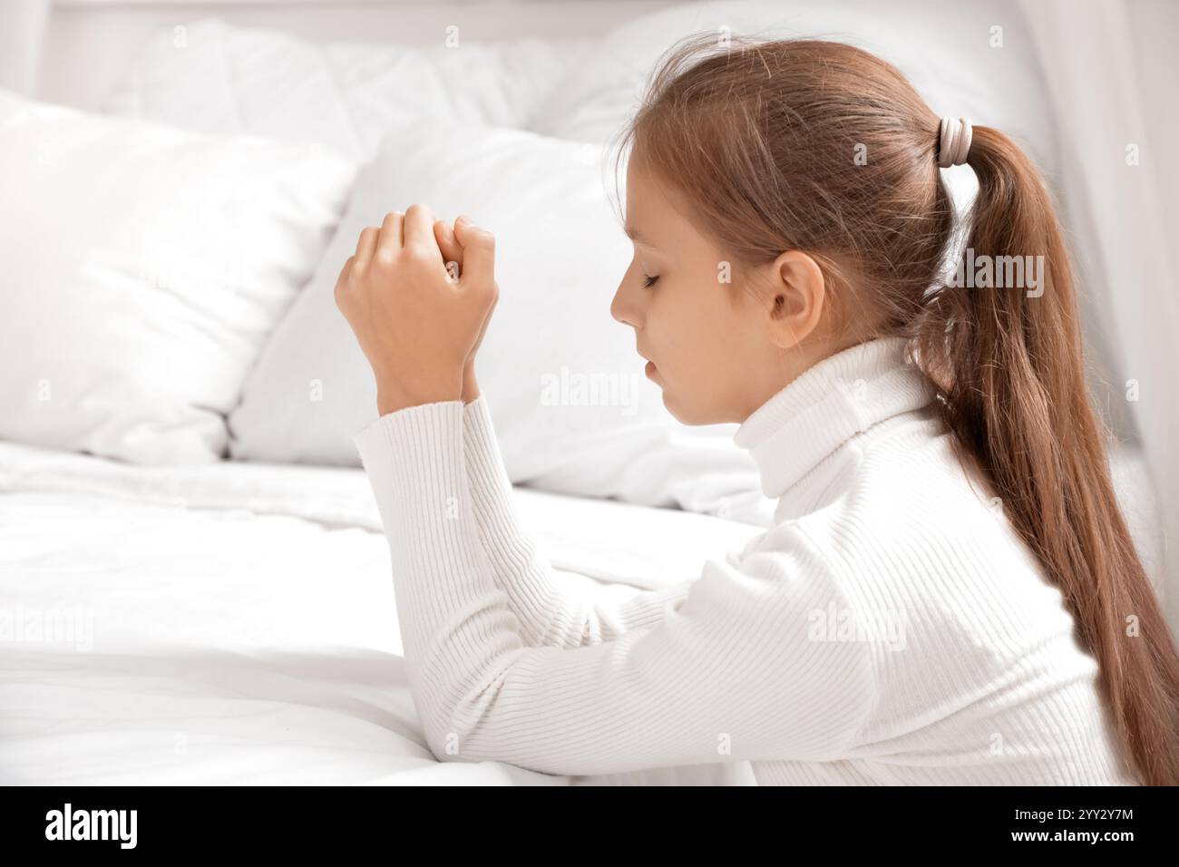 Teenage girl praying near bed at home Stock Photo - Alamy