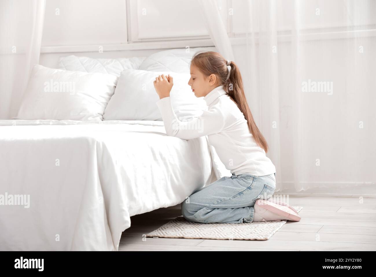 Teenage girl praying near bed at home Stock Photo - Alamy