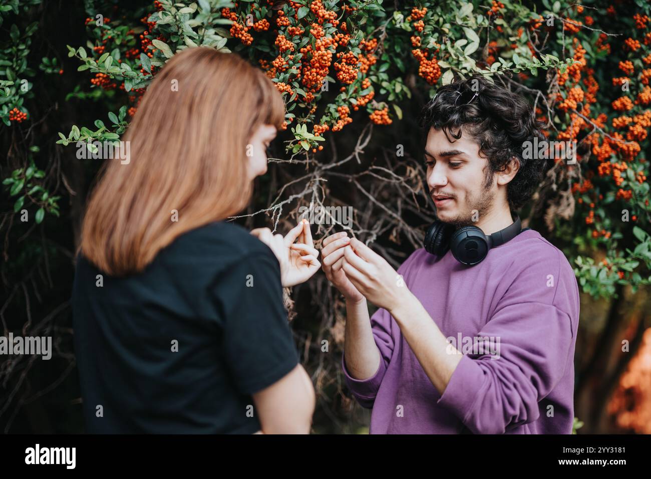 Two friends enjoying nature and conversation near berry bush Stock ...
