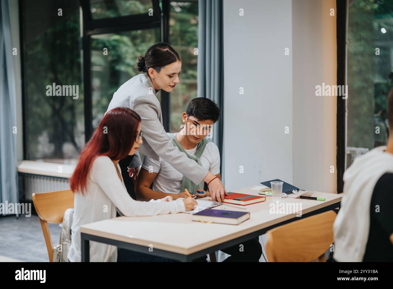 Teacher assisting students in a modern classroom setting Stock Photo ...