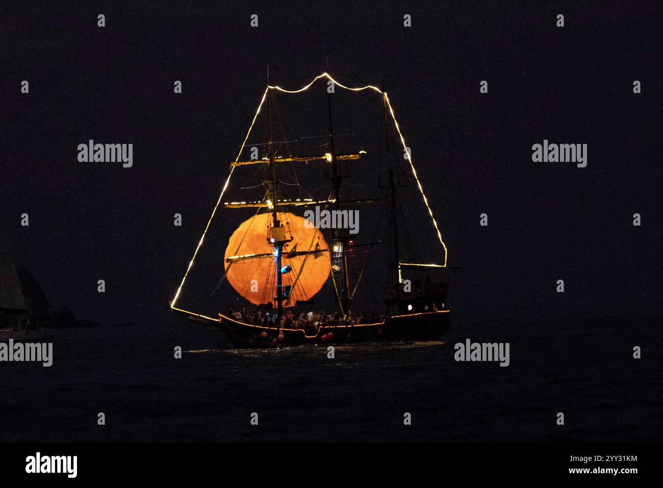 Cold Moon rises behind a boat in Cabo San Lucas Mexico in December 2024 ...
