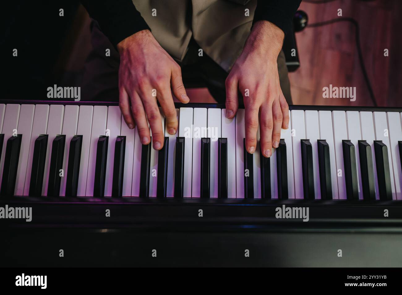 A close up view of a musician's hands playing the piano, focusing on ...