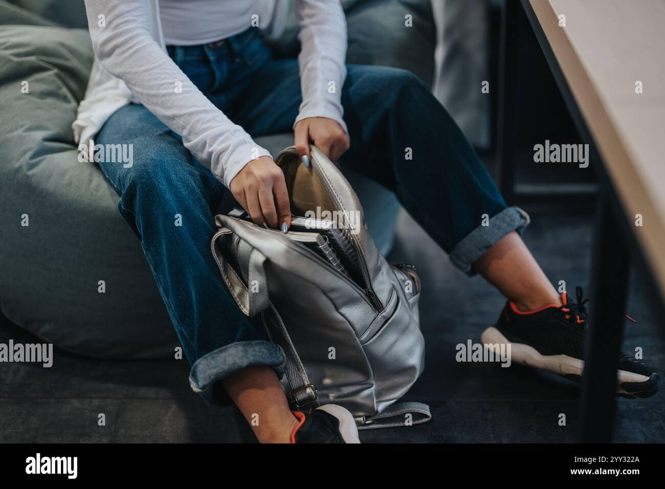 High school student packing books into a backpack in study area Stock ...