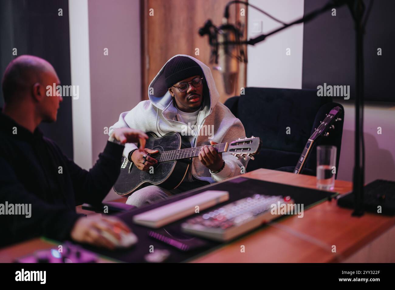 Musicians collaborating in a modern recording studio with acoustic ...