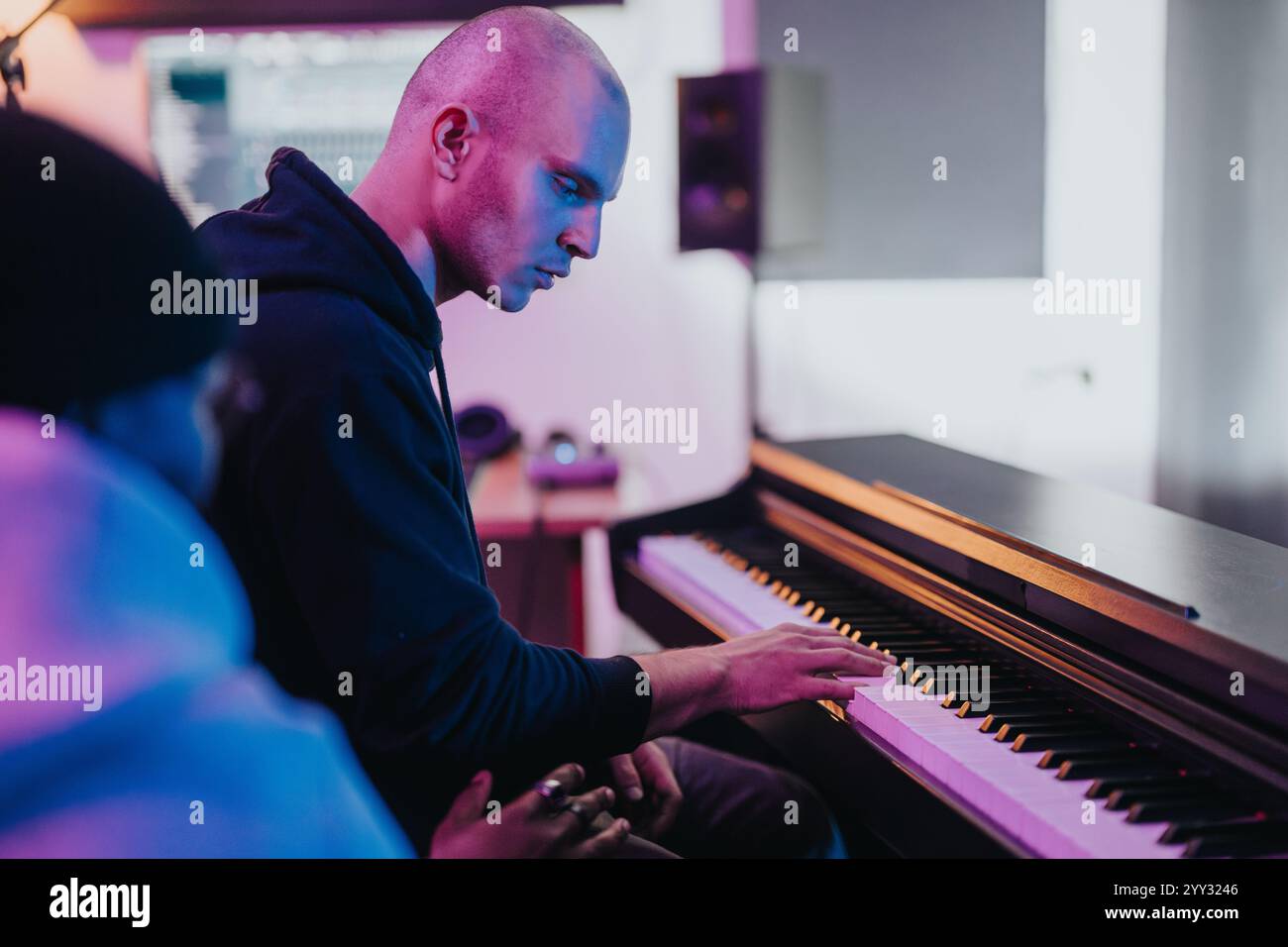 Musicians collaborating in a modern music studio with keyboard and ...