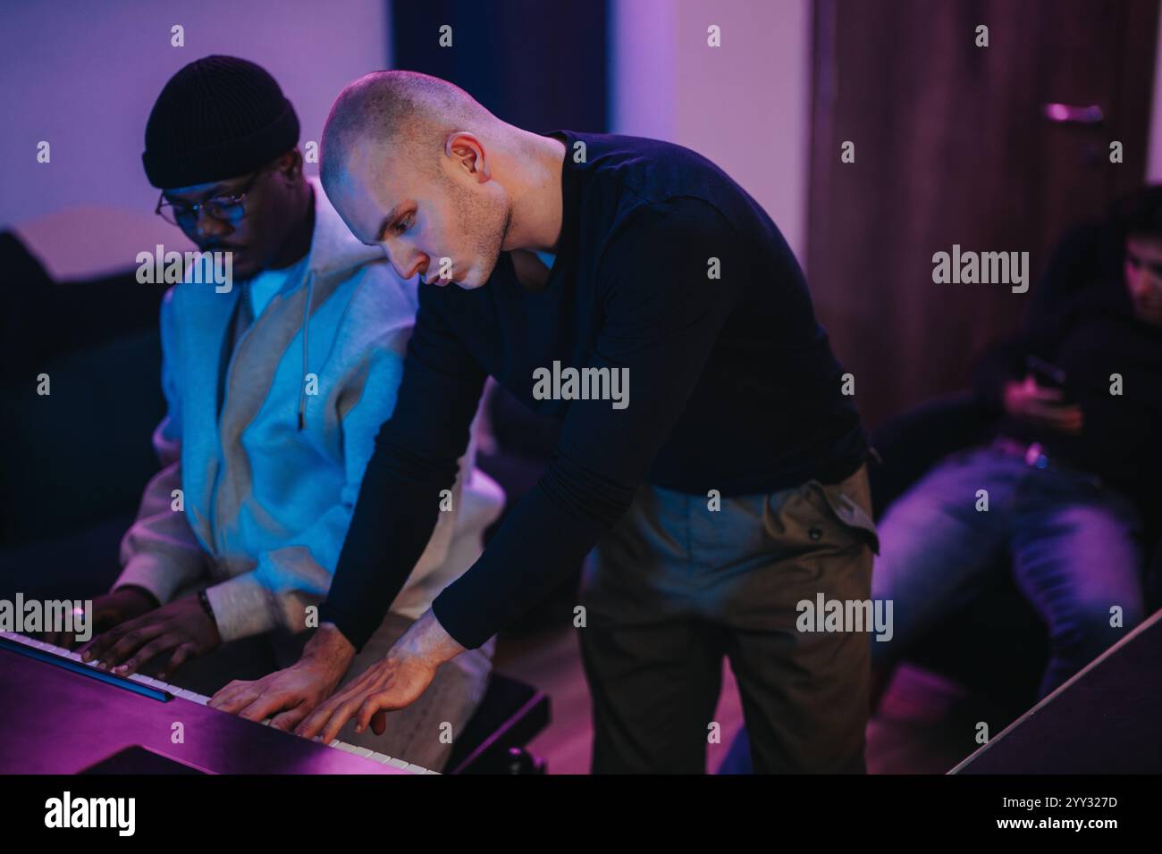 Two musicians collaborate on a piano, blending creativity and skill in ...