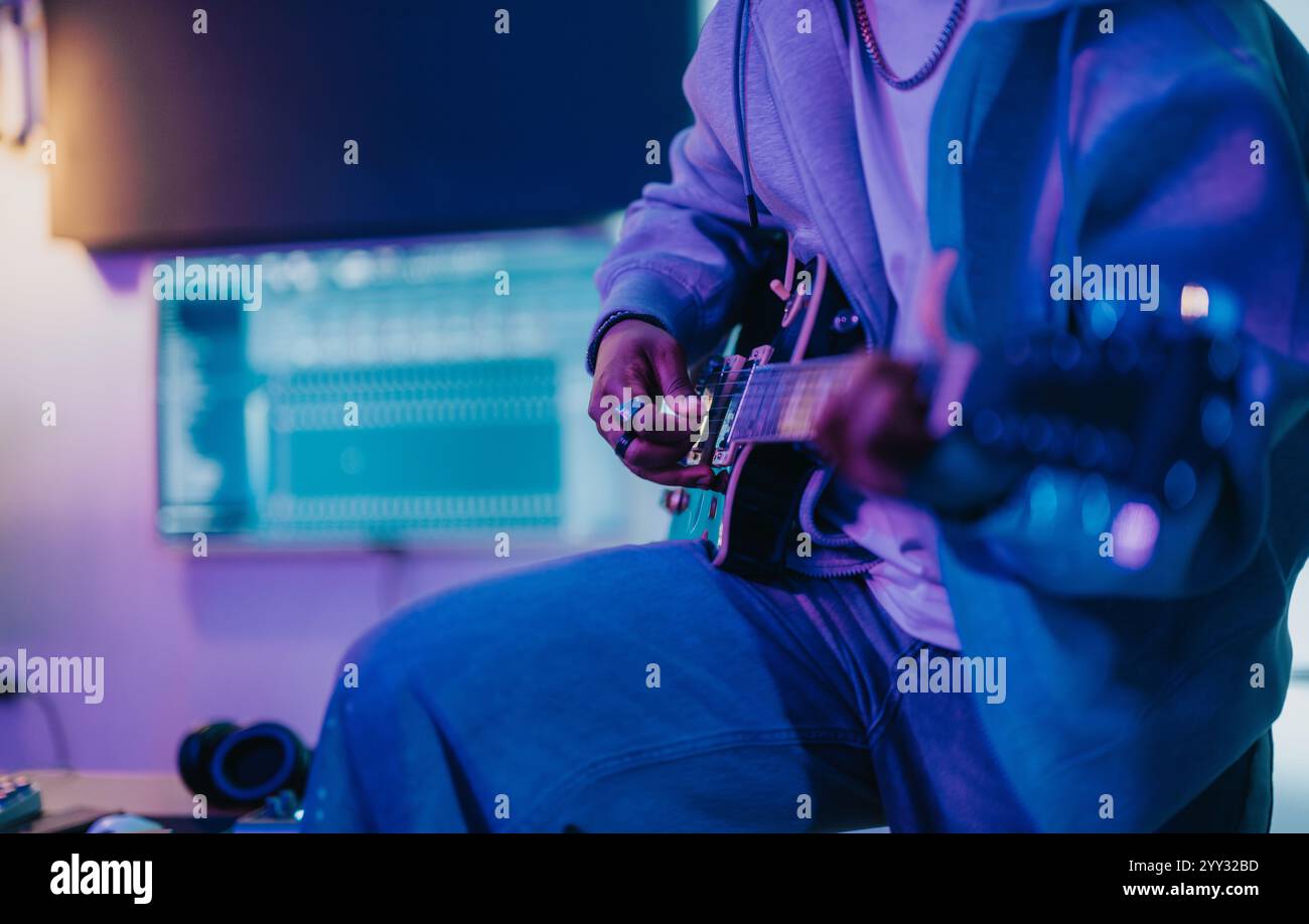 Musician playing electric guitar in a modern recording studio setting ...