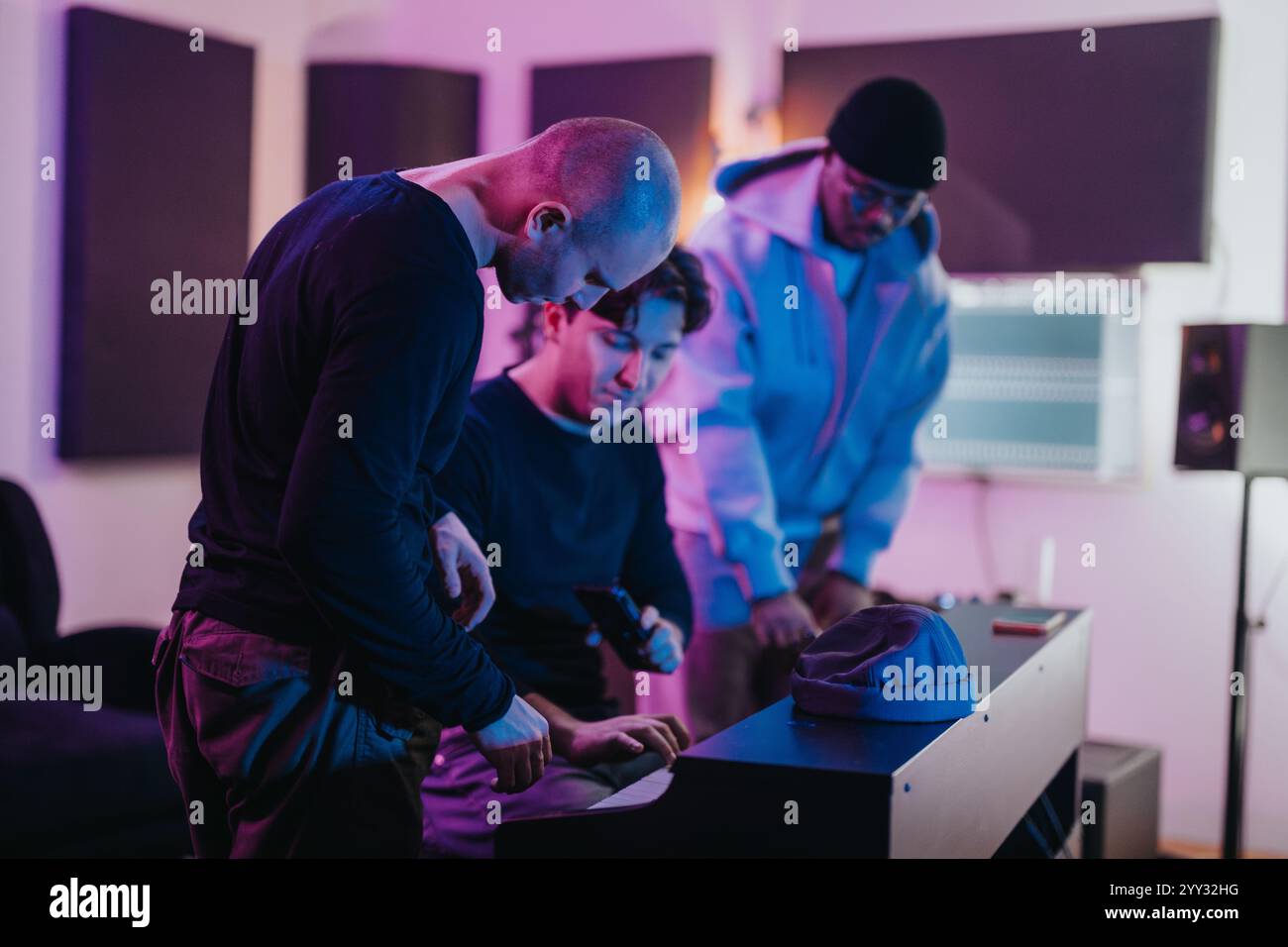 Multiracial musicians collaborating in a modern recording studio ...