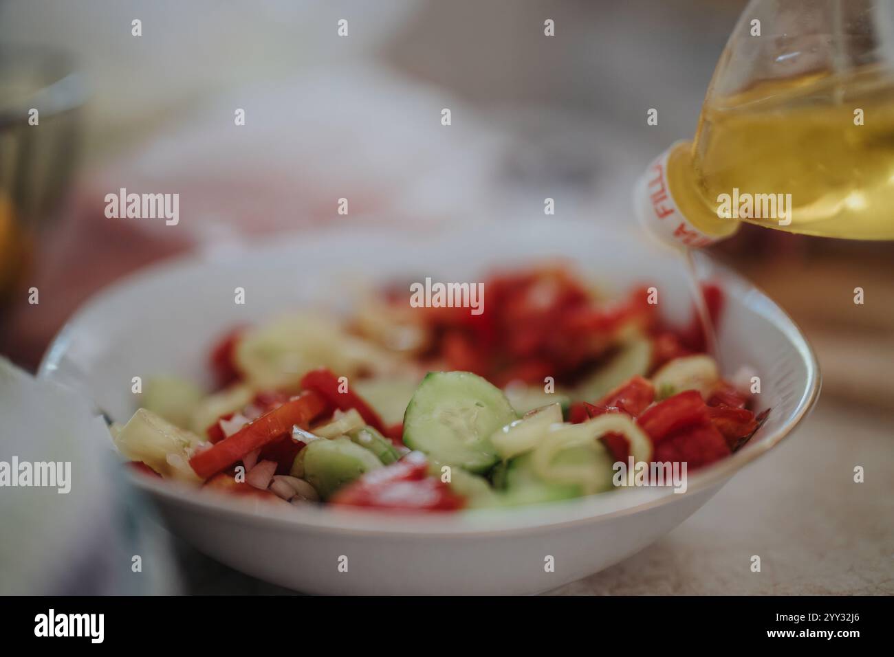 Fresh vegetable salad with olive oil being poured in kitchen Stock ...