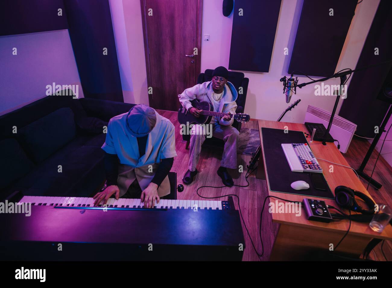 Multiracial musicians collaborating in a recording studio with guitar ...