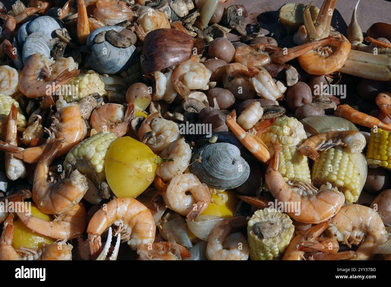 A seafood boil of shellfish including crab and shrimp mixed with ...