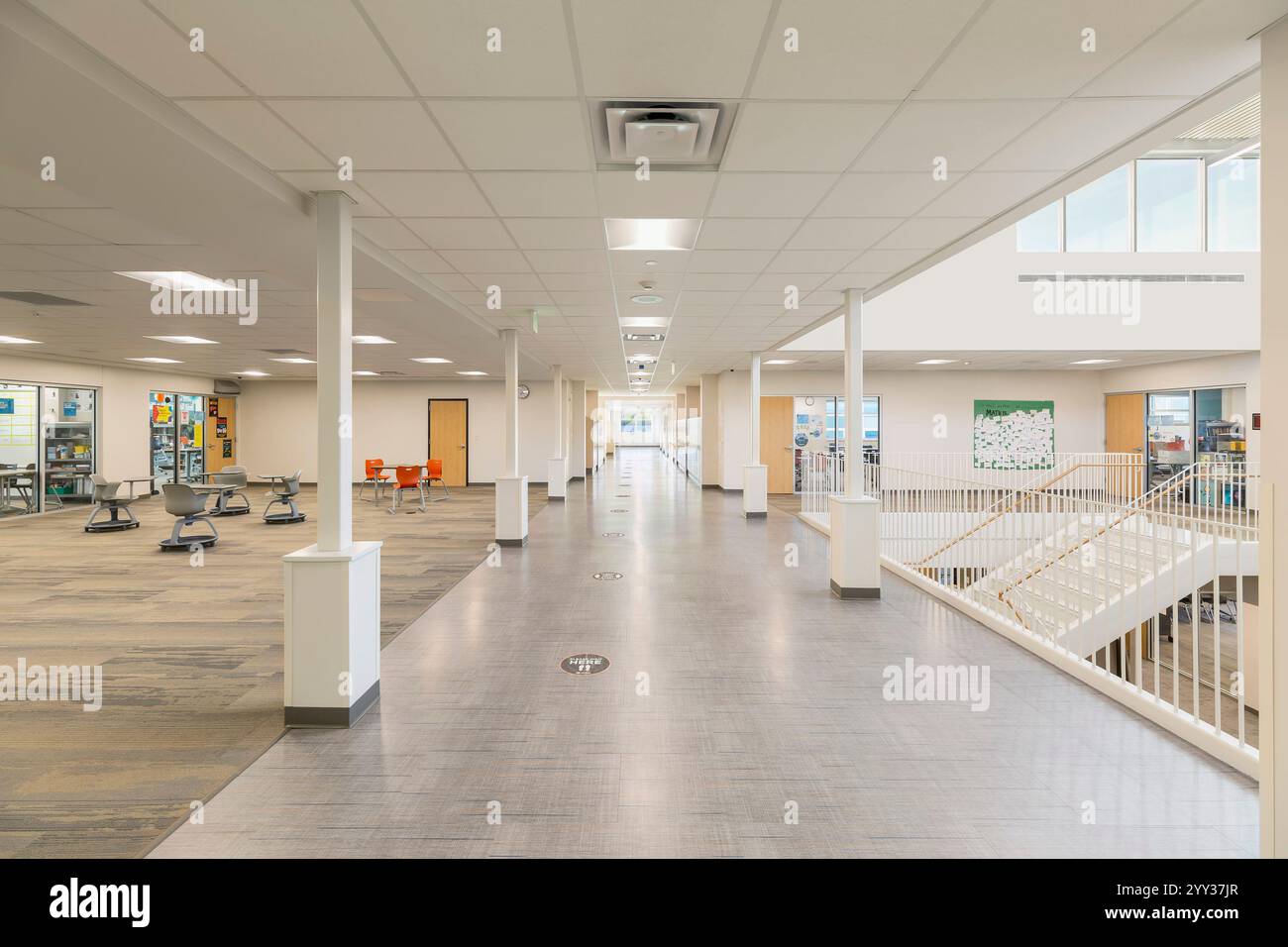 Middle school hall and common space with classrooms and stairs next to ...