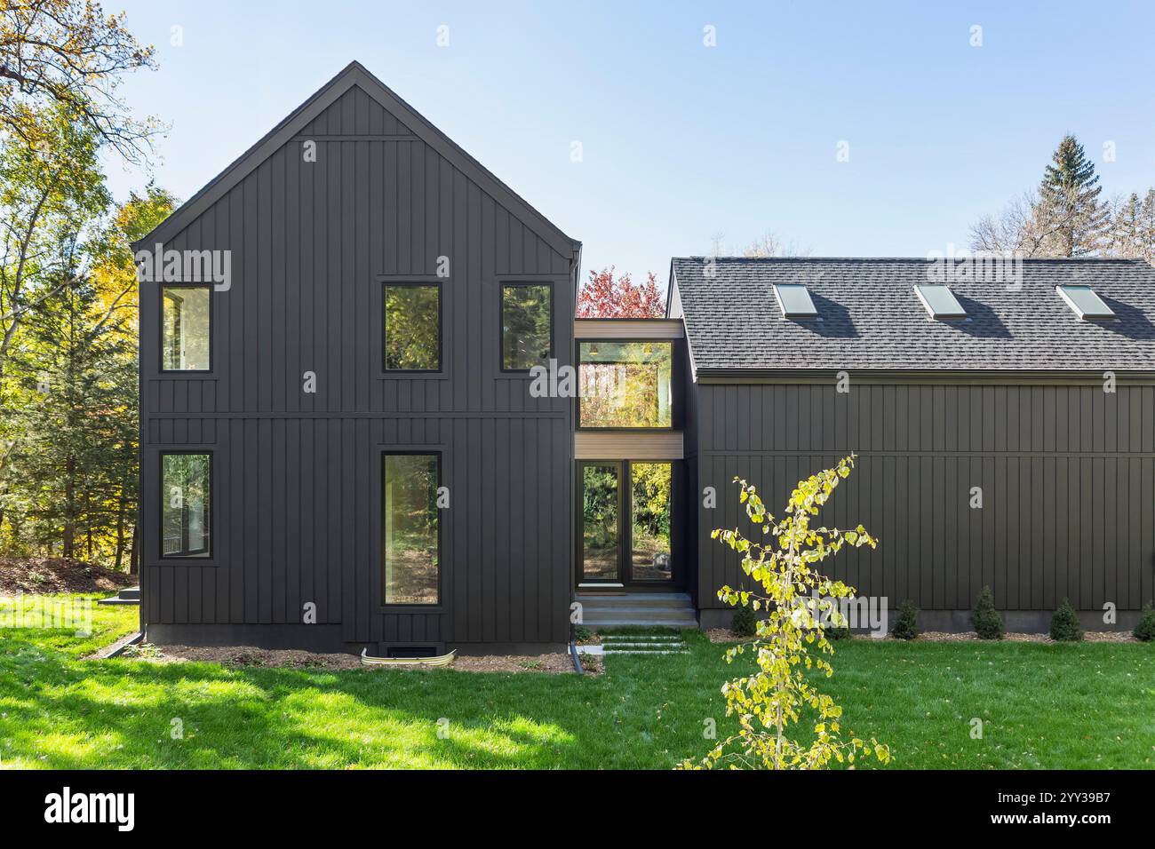 Black house with two sections joining in the middle with a glass ...