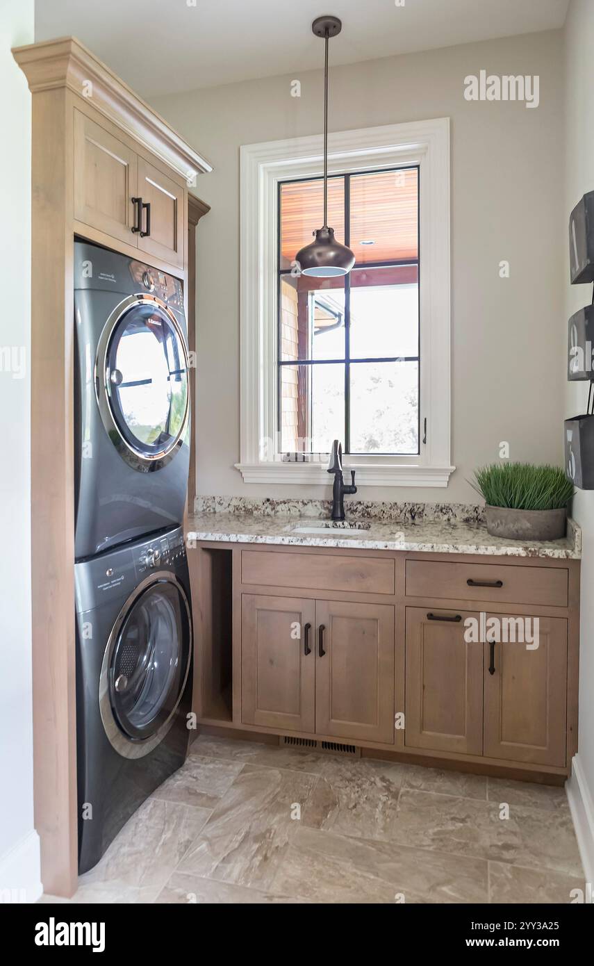 Lower level laundry room with sink and window to outside Stock Photo ...