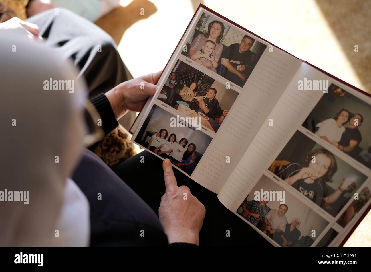 Samar Safadi looks at family photos after speaking by phone with her ...