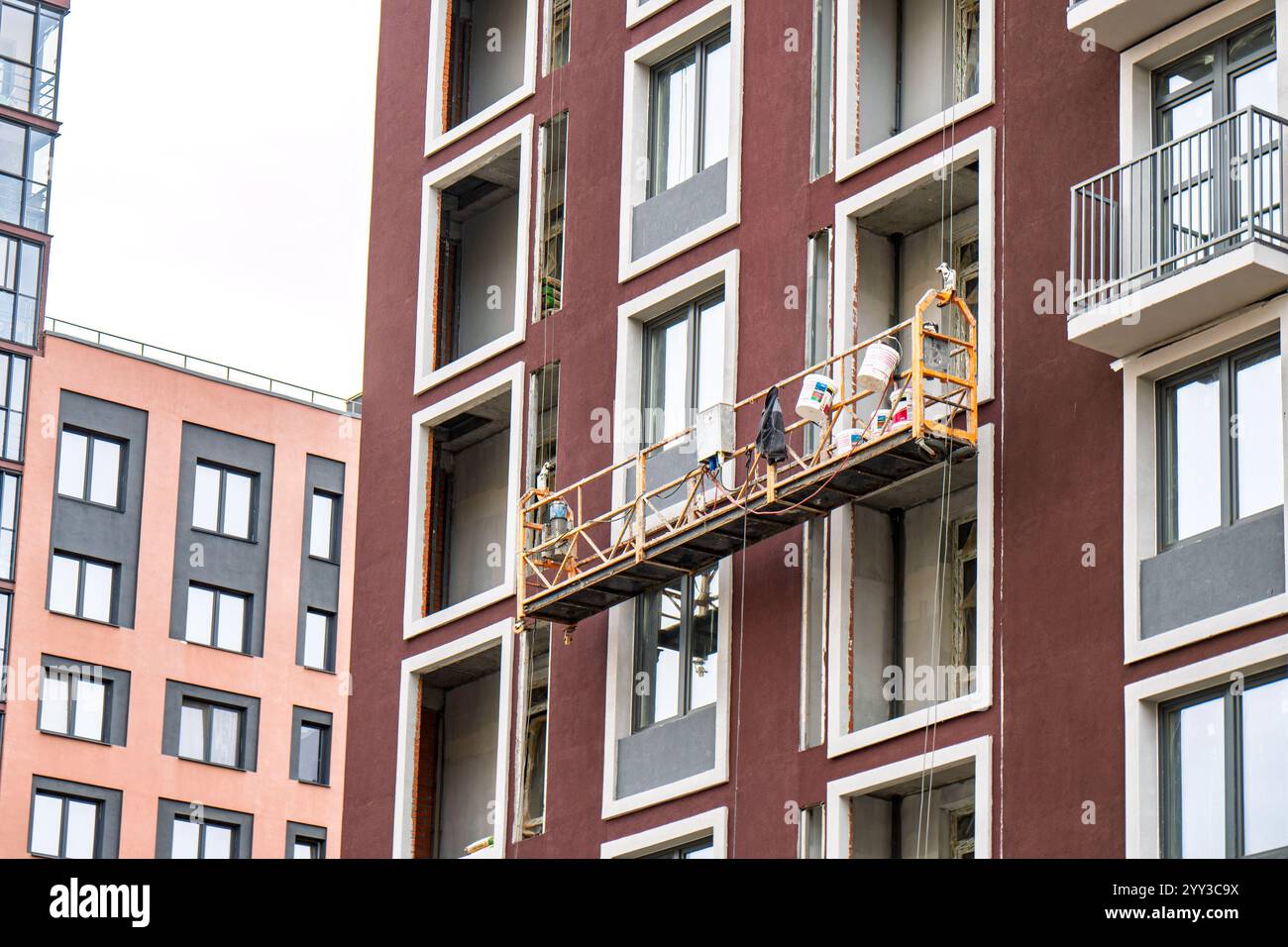 Construction scaffold suspended in front of a modern building facade ...