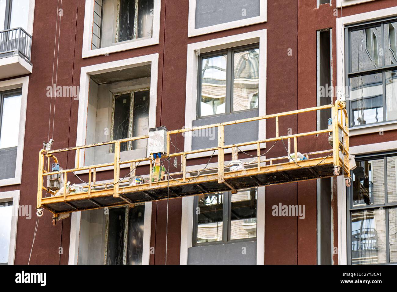 Construction scaffold suspended in front of a modern building facade ...