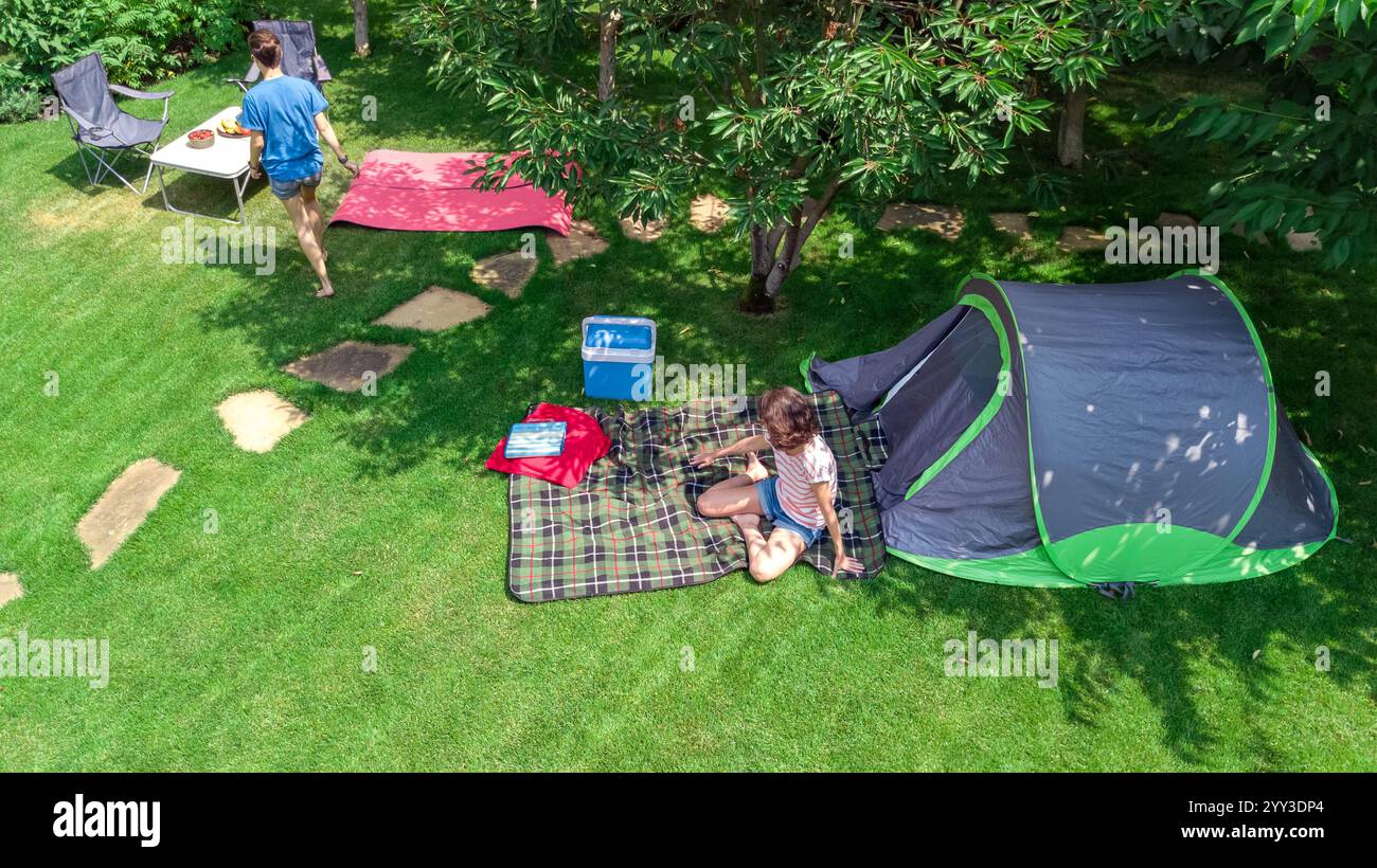 Aerial top view of campsite from above, mother and daughter having fun ...