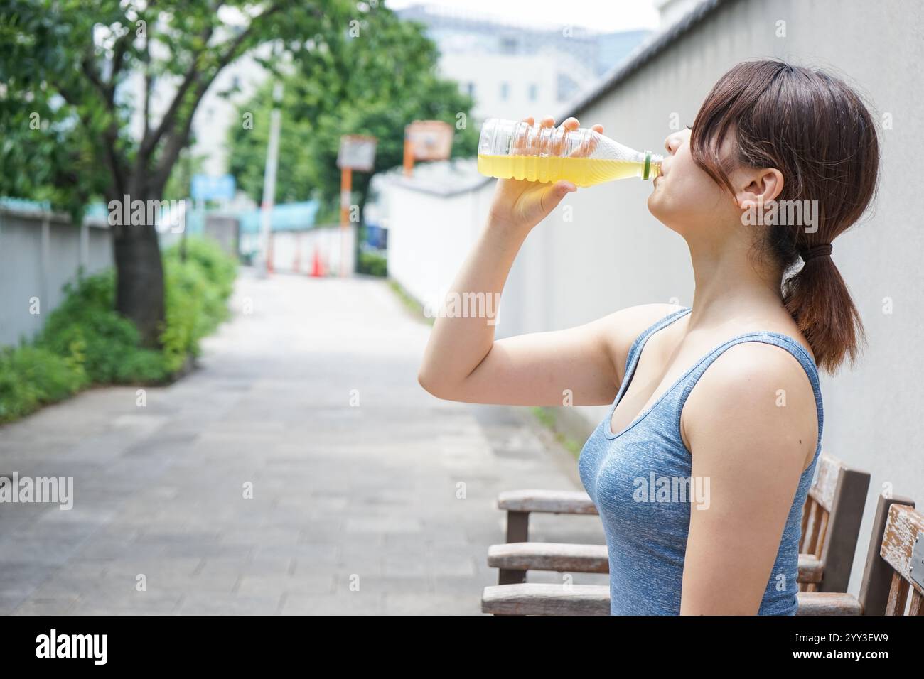 Young woman hydrating during sport Stock Photo - Alamy