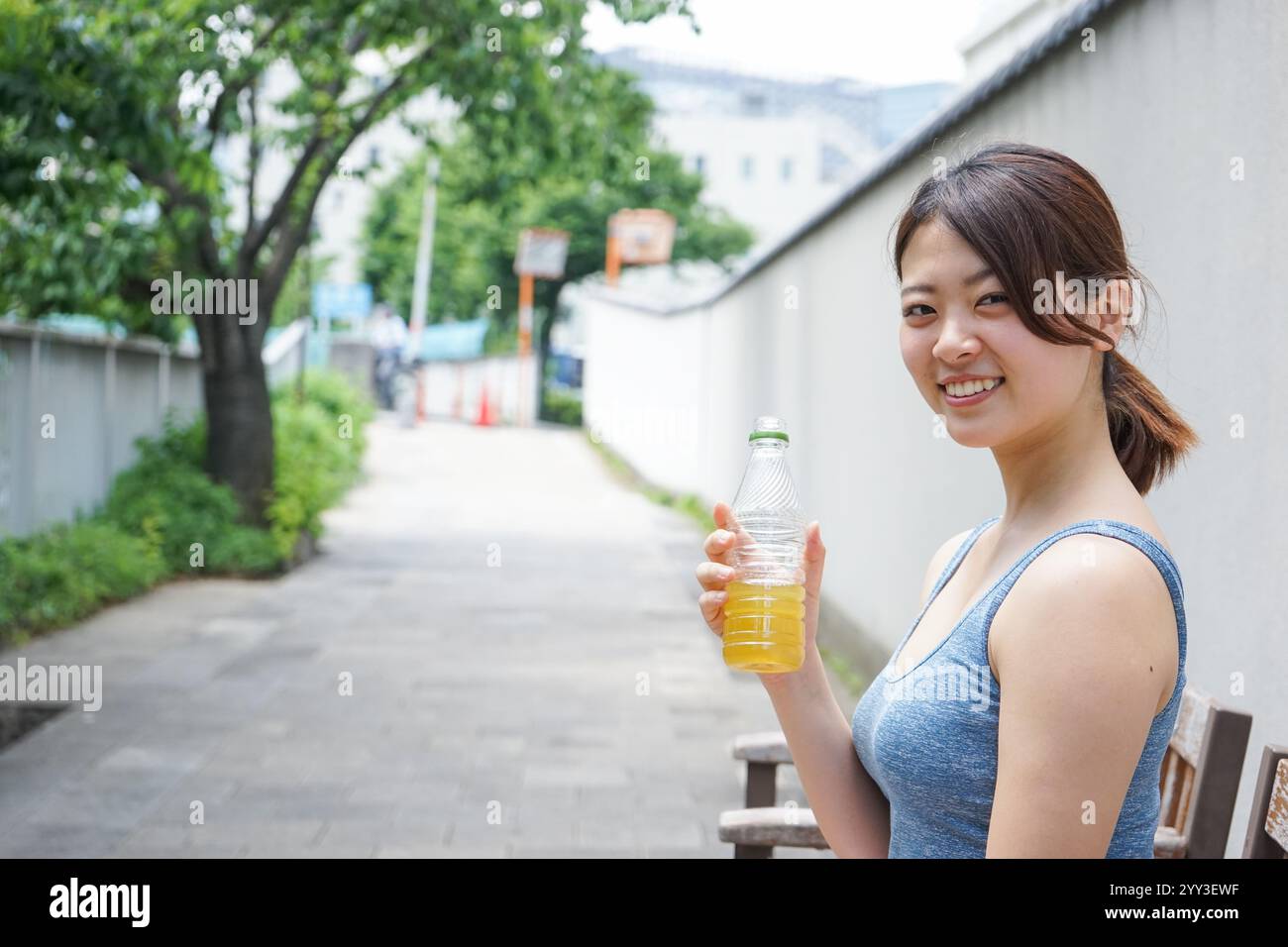 Young woman hydrating during sport Stock Photo - Alamy