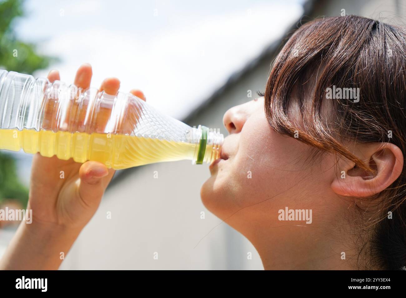 Young woman hydrating during sport Stock Photo - Alamy