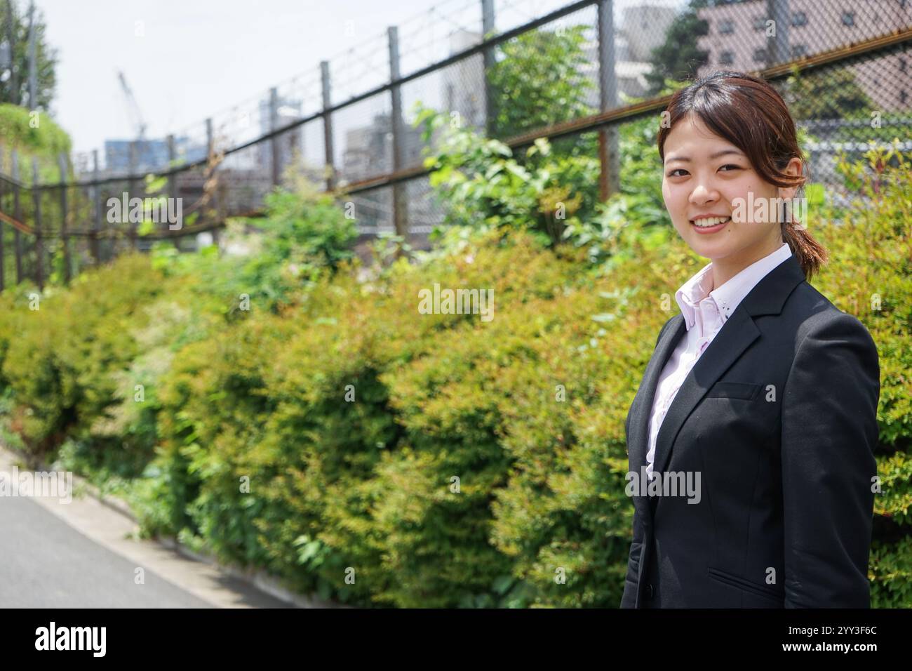 Businesswoman walking outside with a smile Stock Photo - Alamy
