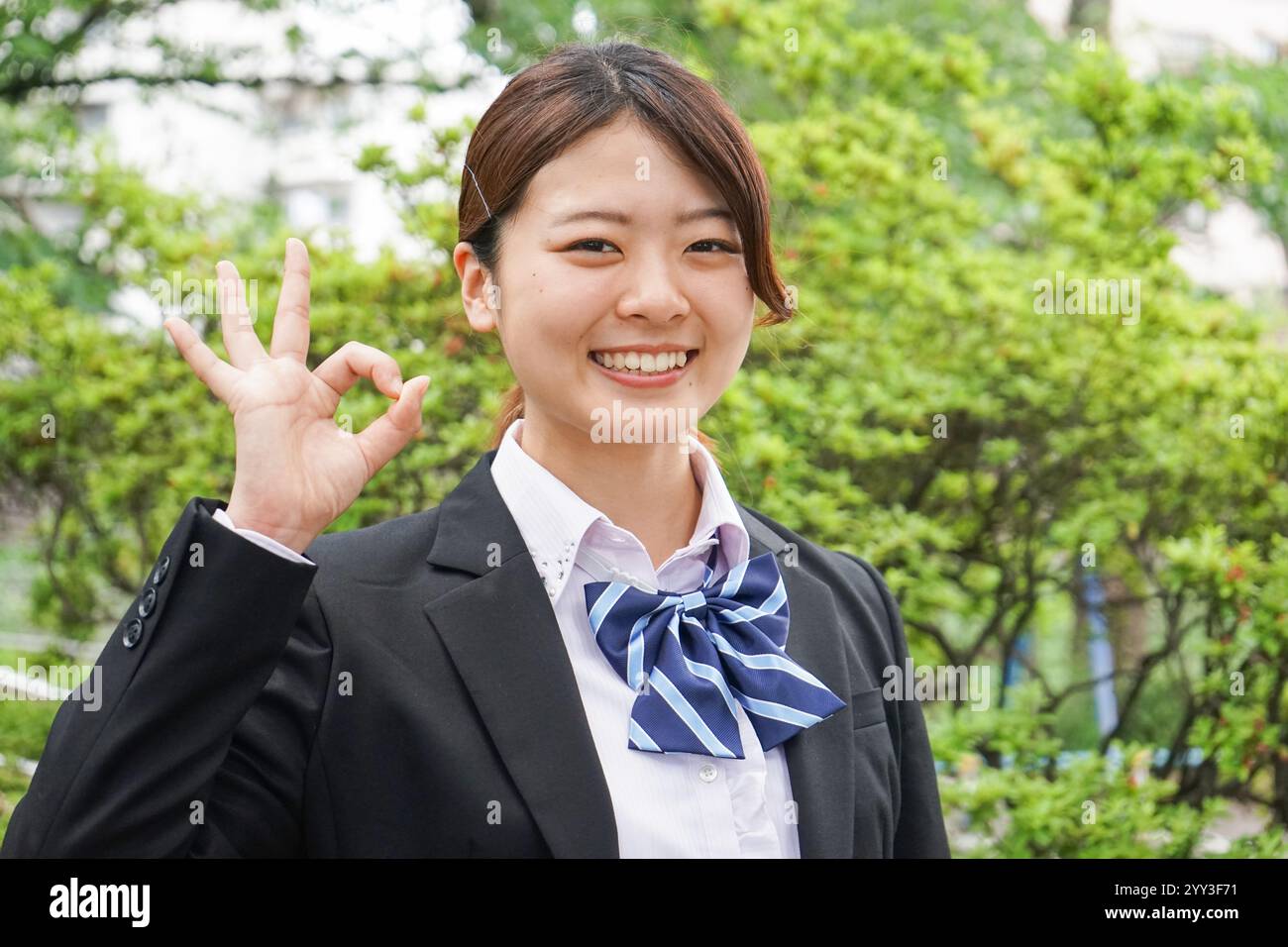Student in uniform smiling and waving Stock Photo - Alamy