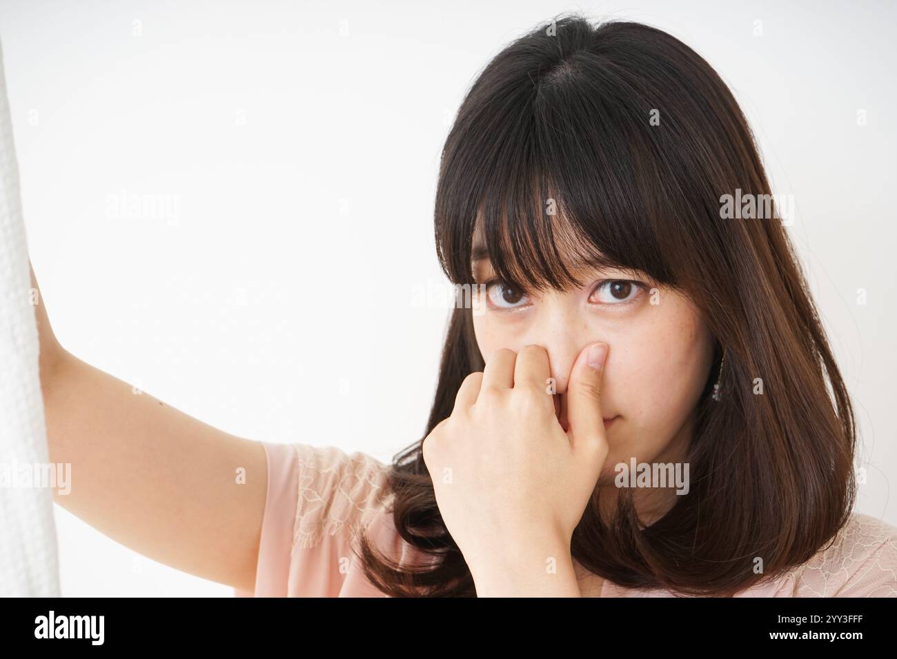 Young woman smelling smelly laundry Stock Photo - Alamy