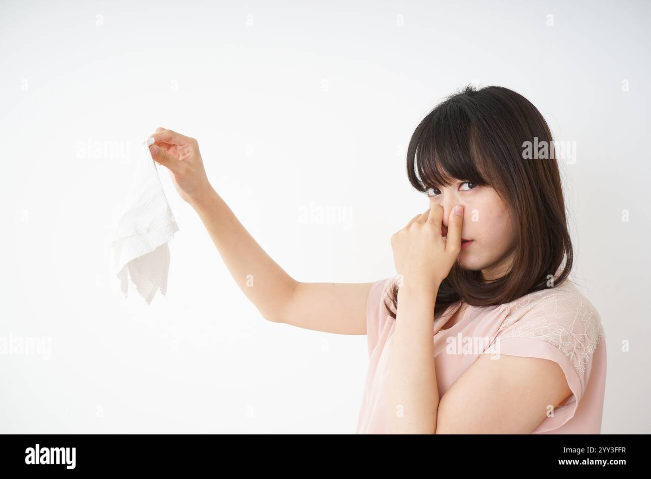 Young woman smelling smelly laundry Stock Photo - Alamy