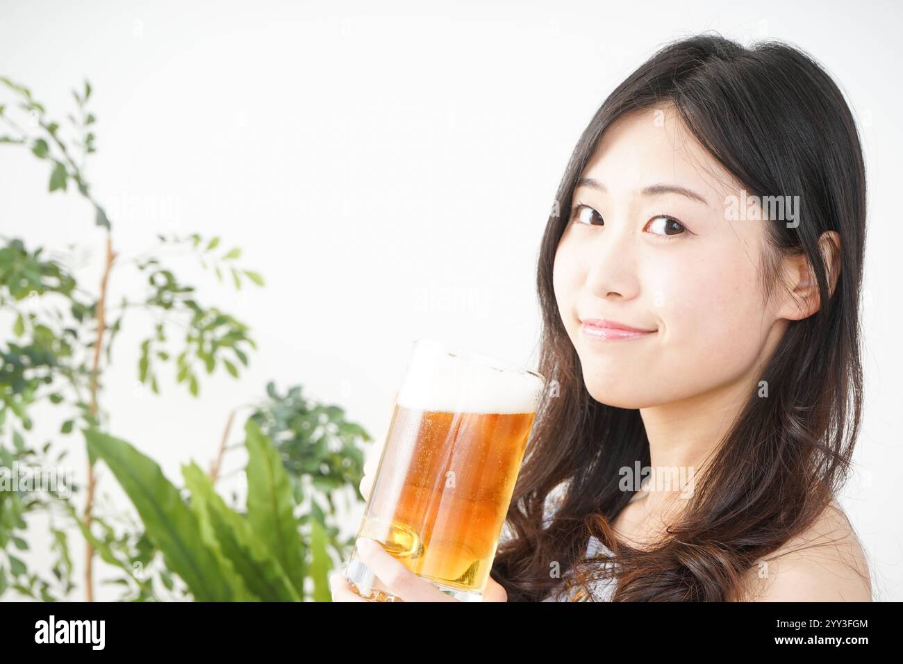 Young woman drinking beer in room Stock Photo - Alamy